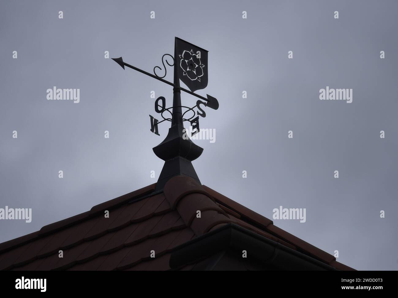 Antique wind cardinal direction compass on a clay tile rooftop in ...
