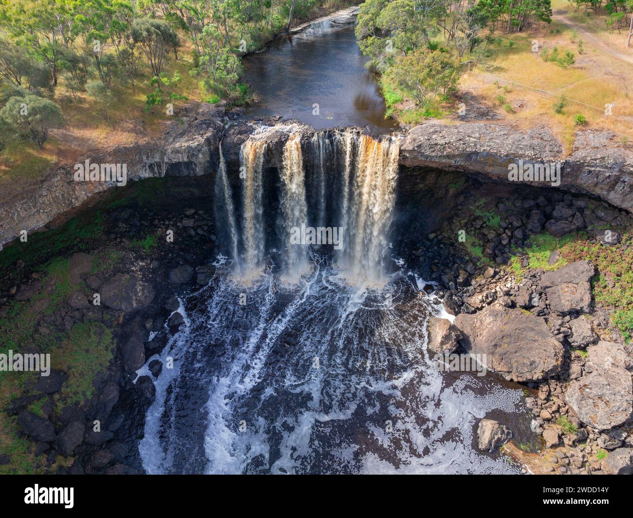 Aerial view of a waterfall tumbling over a rock ledge into a large open ...