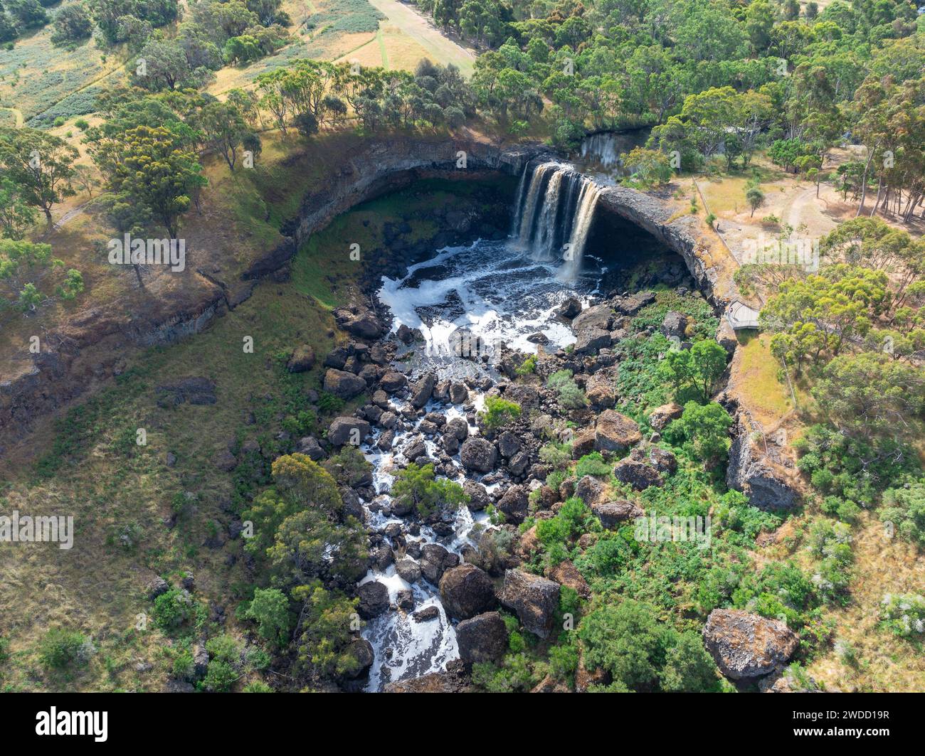Aerial view of a waterfall tumbling over a rock ledge into a large open ...
