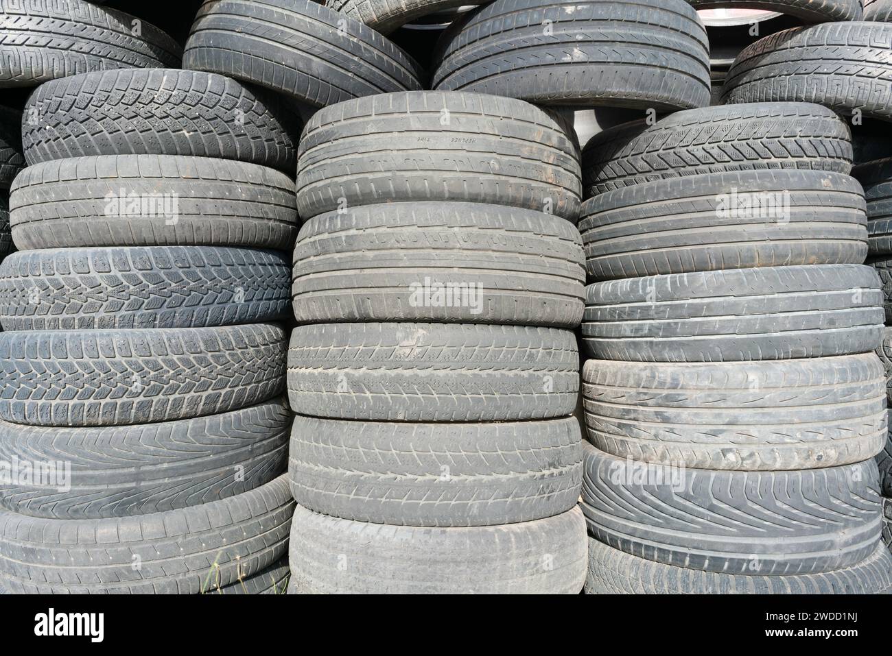 Old used tires stacked with high piles Stock Photo - Alamy