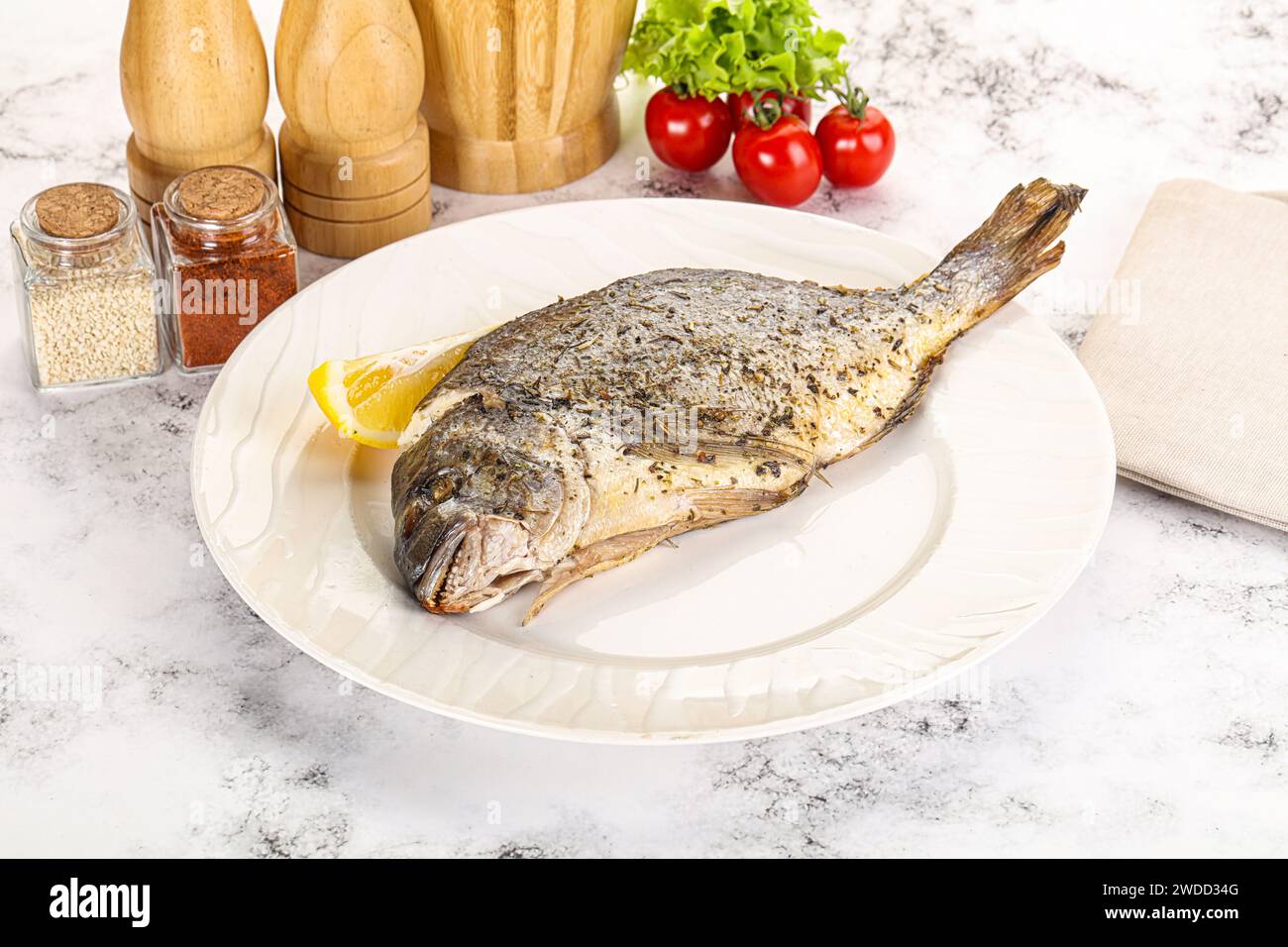 Baked Dorado fish served lemon slice Stock Photo - Alamy