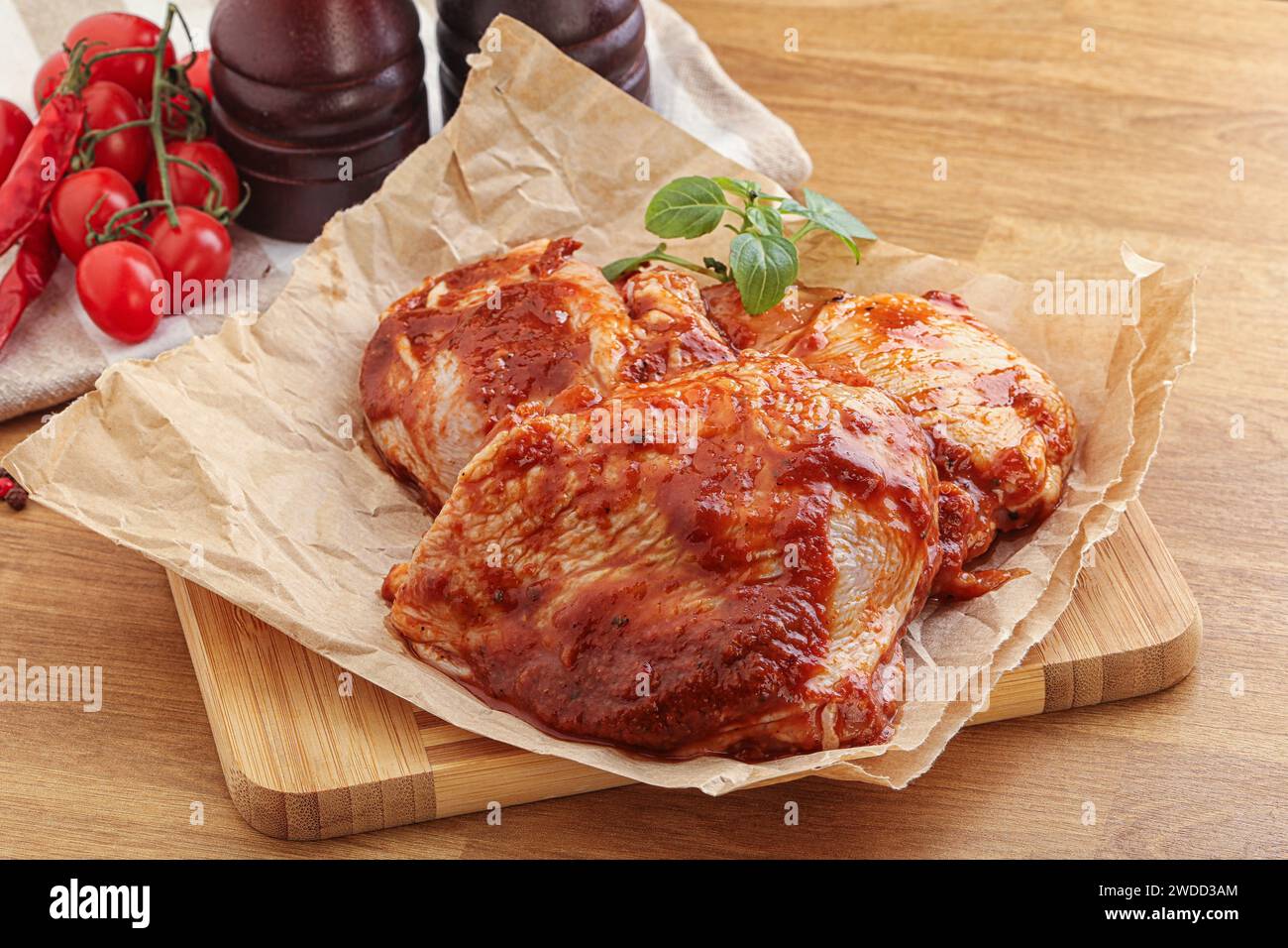 Marinated chicken leg thighs in tomato sauce Stock Photo - Alamy