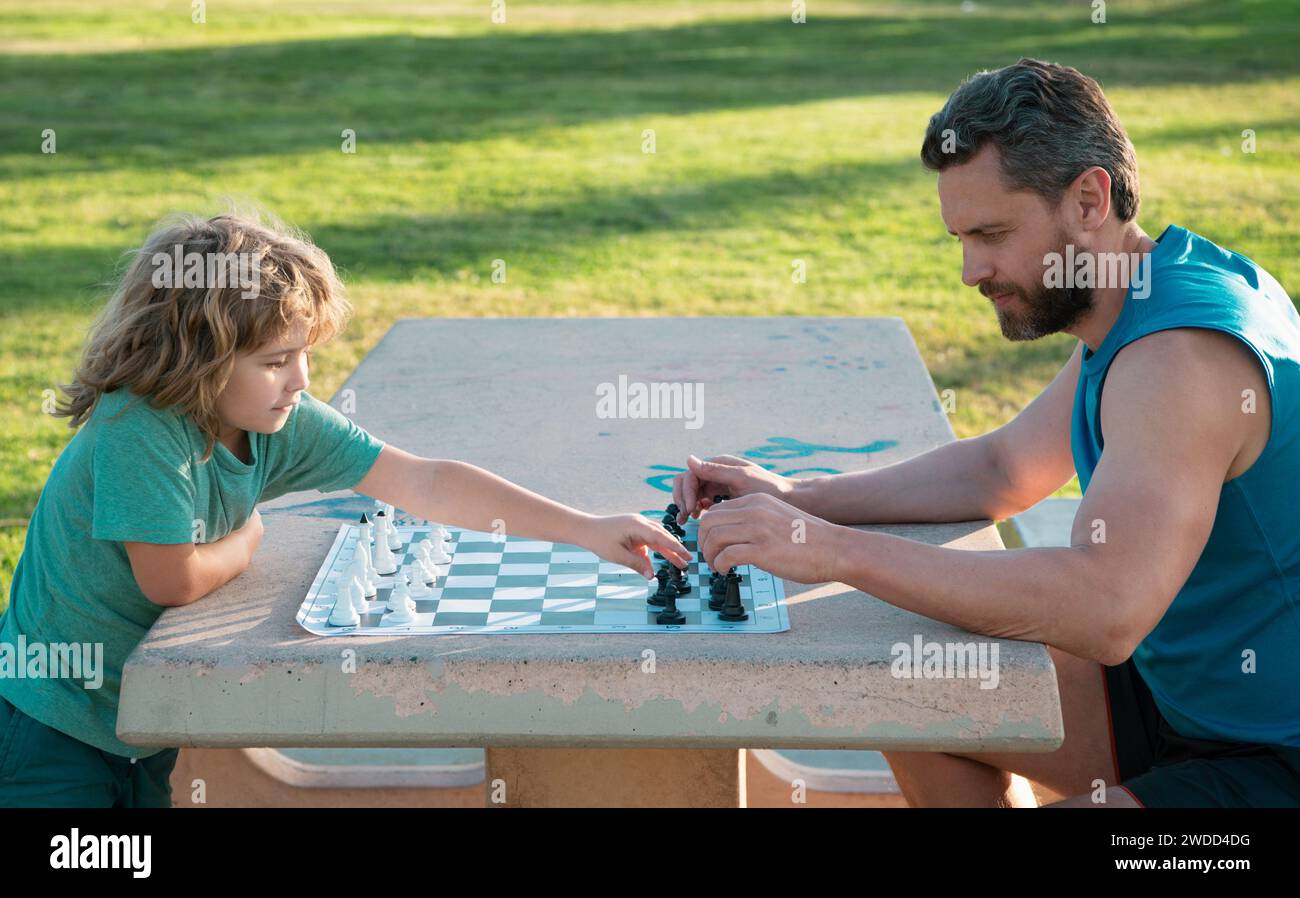 Father and son playing chess spending time together in park. Child ...