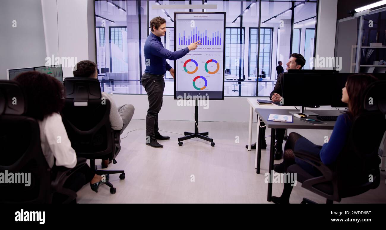 Diverse Team Meeting With TV Screen. Presenter With Dashboard Stock ...