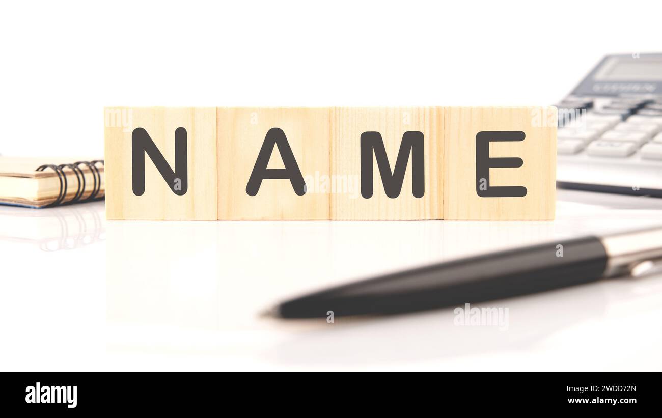 NAME word assembled from wooden cubes next to a calculator, pen and ...