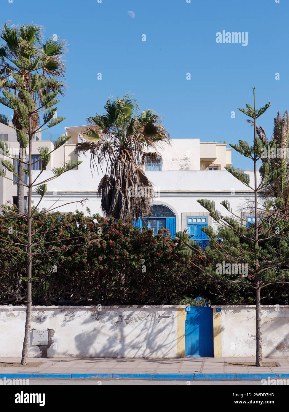 Building with blue door and window with blue sky and the moon above ...