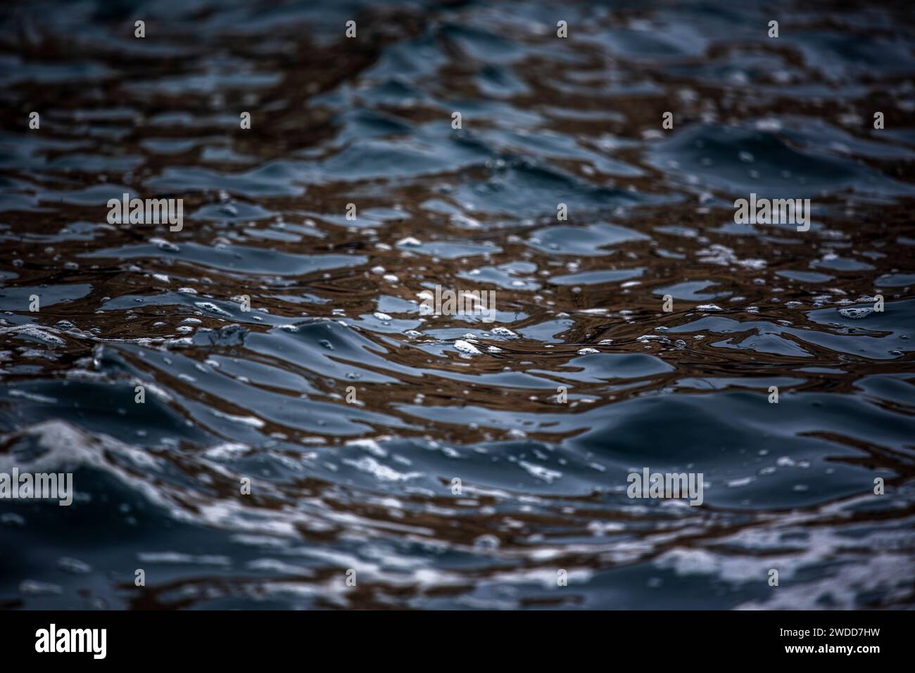 body of water rippled by the wind with reflections of the rippled water ...