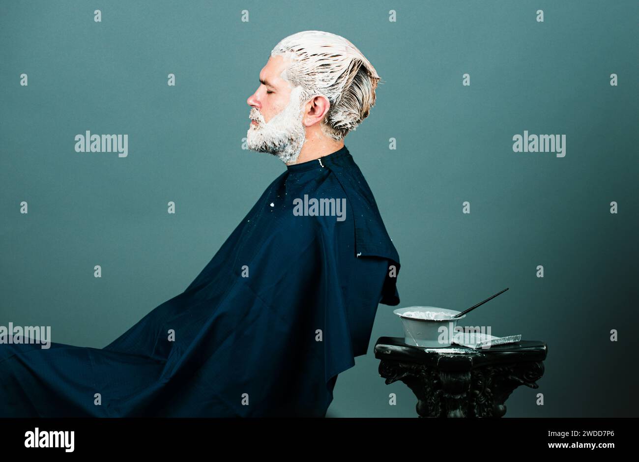 Barber shop. Portrait of bearded man color hair. Process of a man hair ...