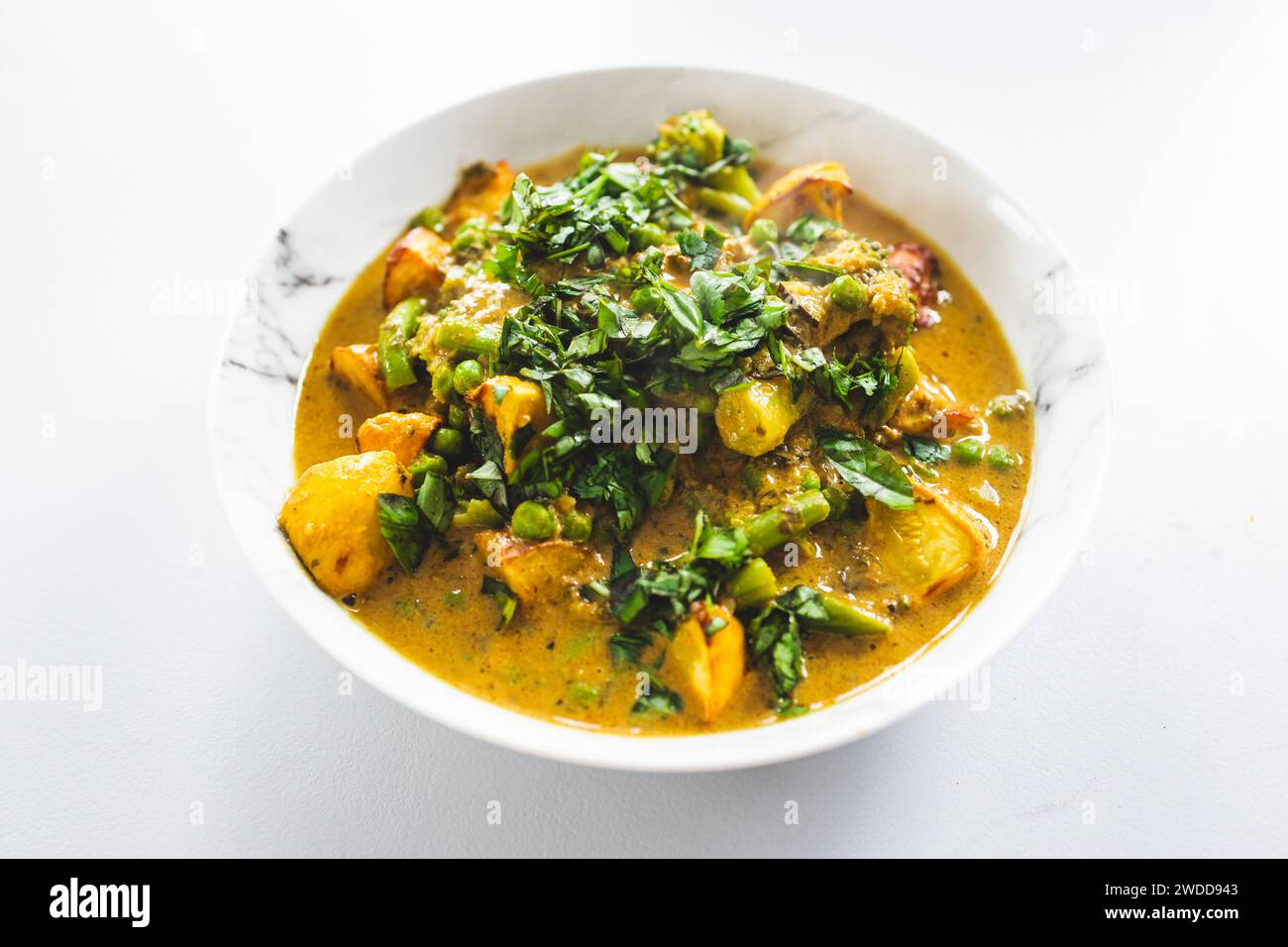 plant-based potato and vegetable green curry with fresh herbs, healthy ...