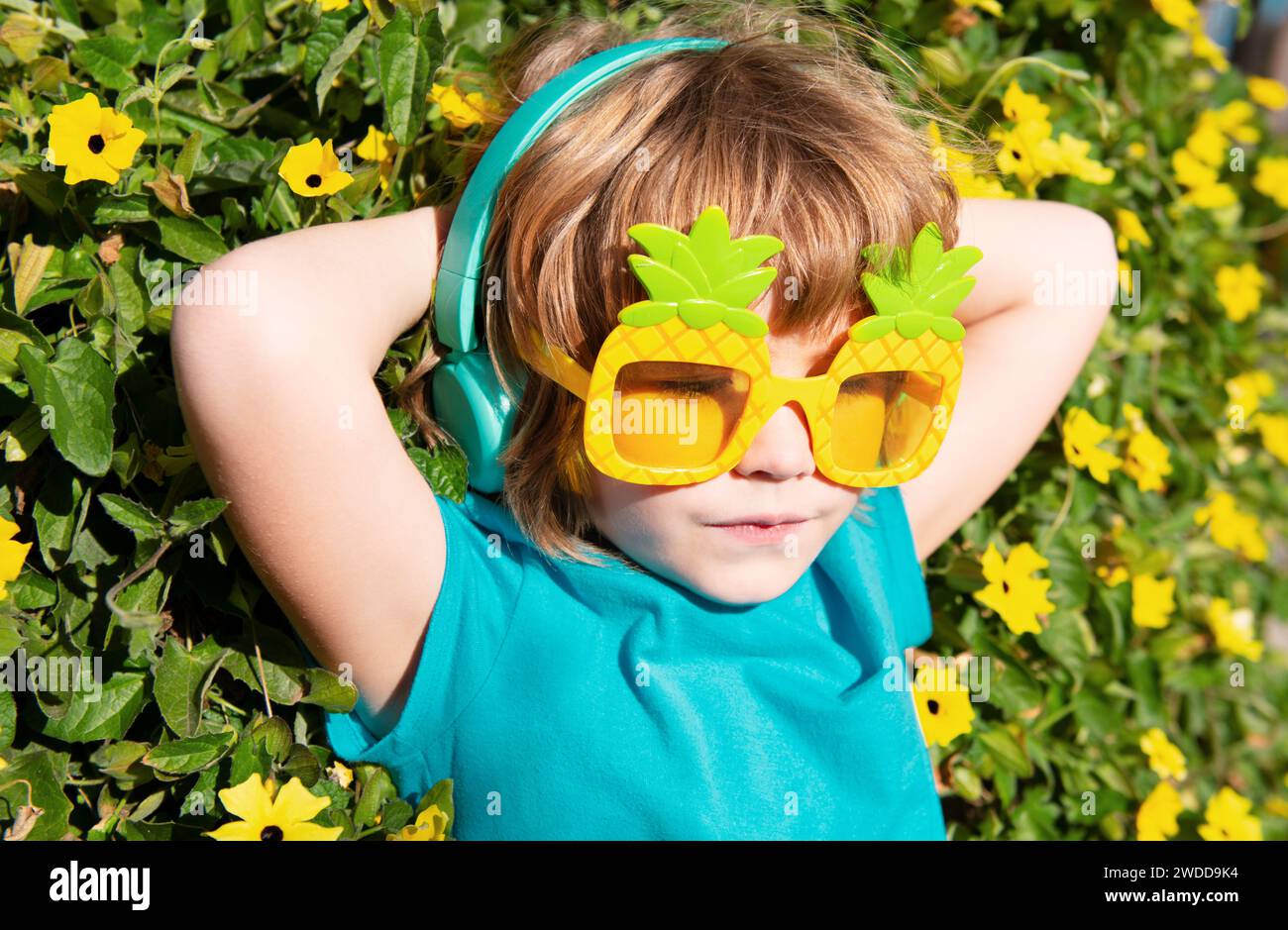 Funny summer mood. Happy kid in crazy glasses and headphones. Happy boy ...