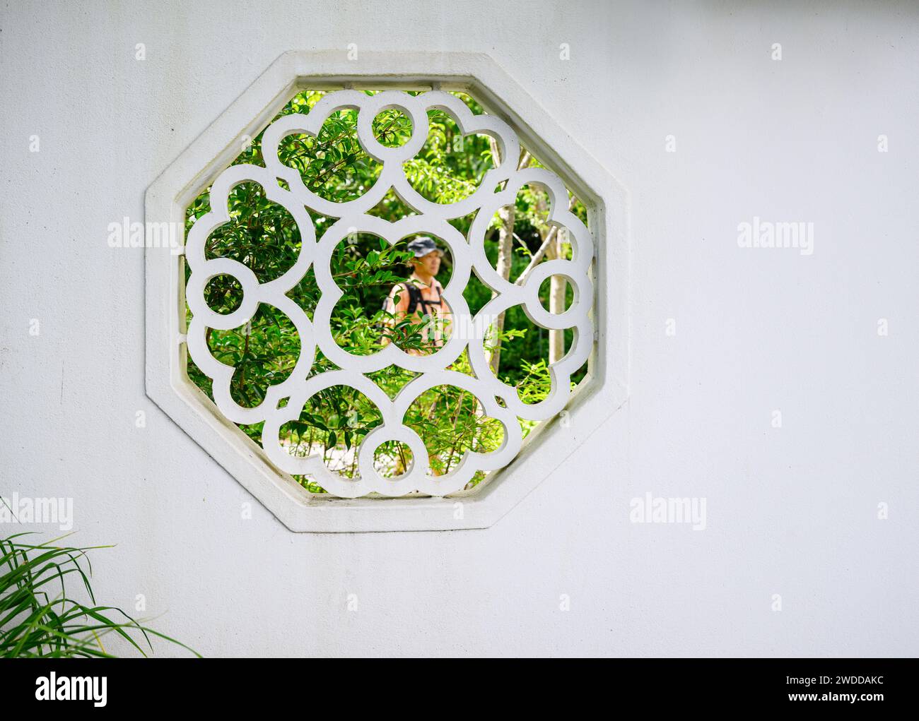 Octagon patterns on a concrete garden wall. People walking behind the ...