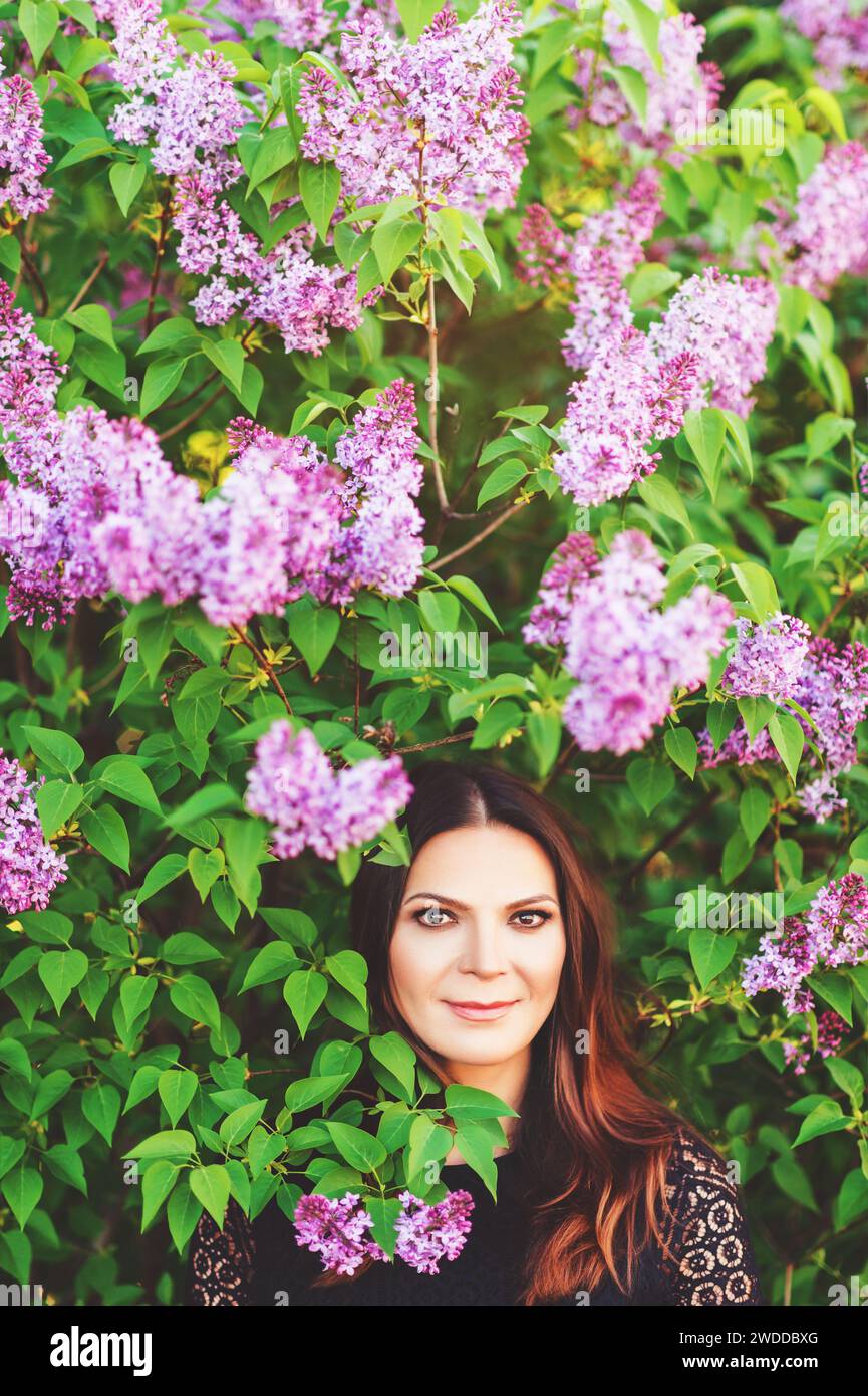 Spring portrait of beautiful brunette woman wearing black lace dress ...