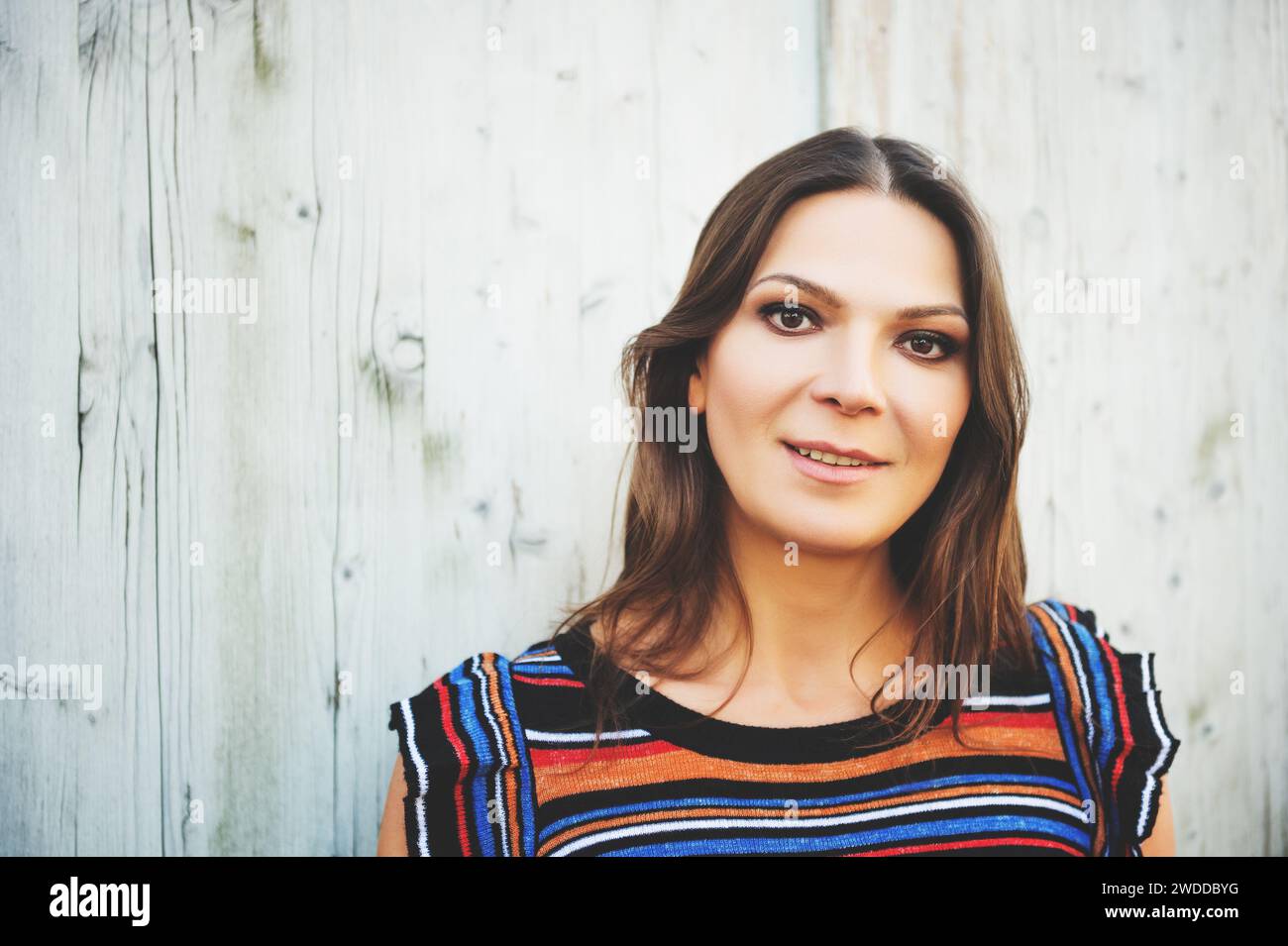 Close up portrait of young beautiful brunette woman waring stripe shirt ...