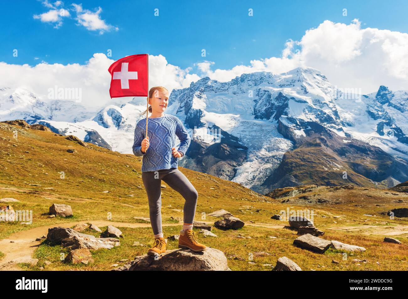 Cute little girl holding swiss flag, standing in front of Gornergrat ...