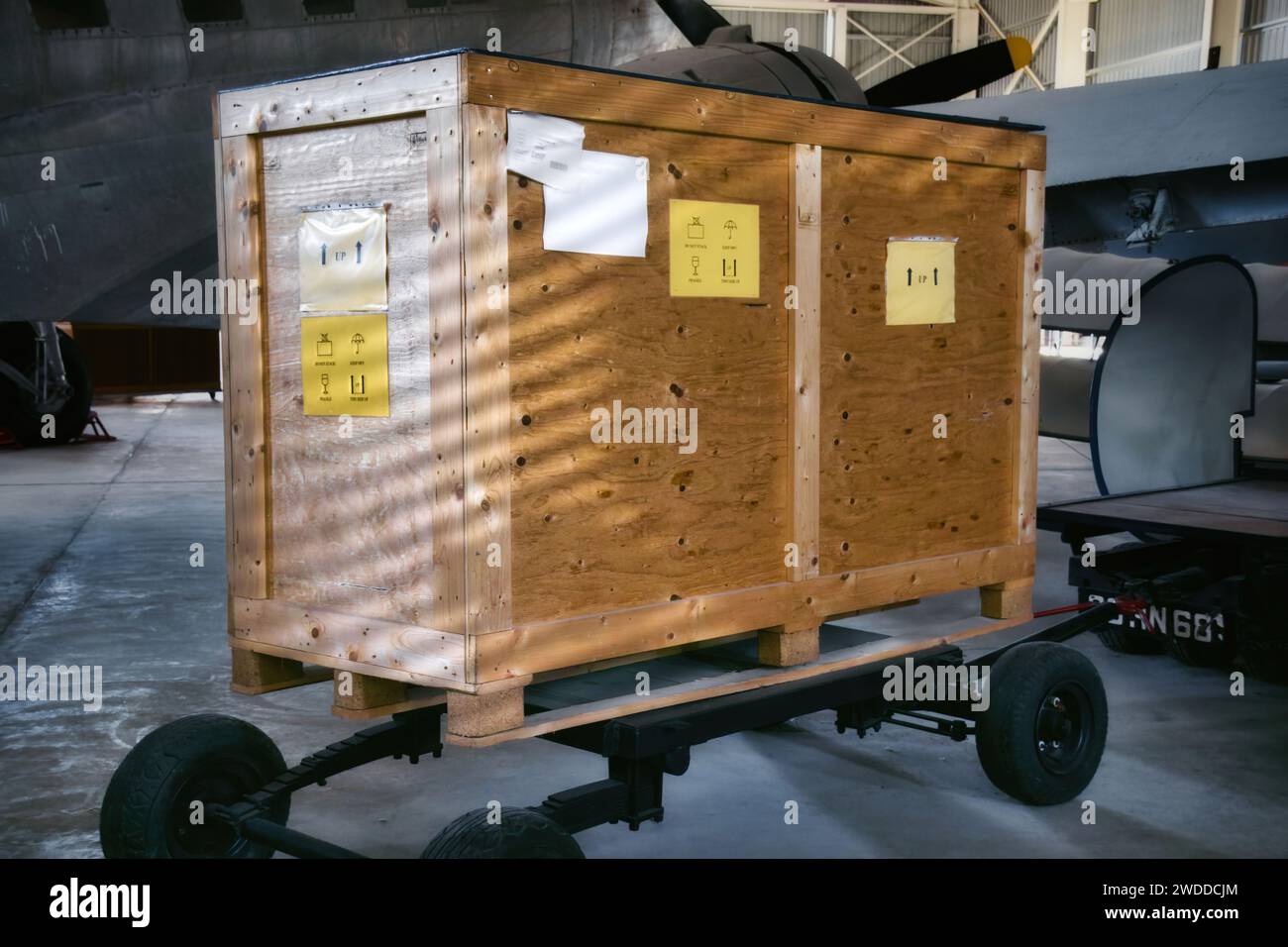A large bulky wooden packing crate in an aircraft hangar, ready to be ...