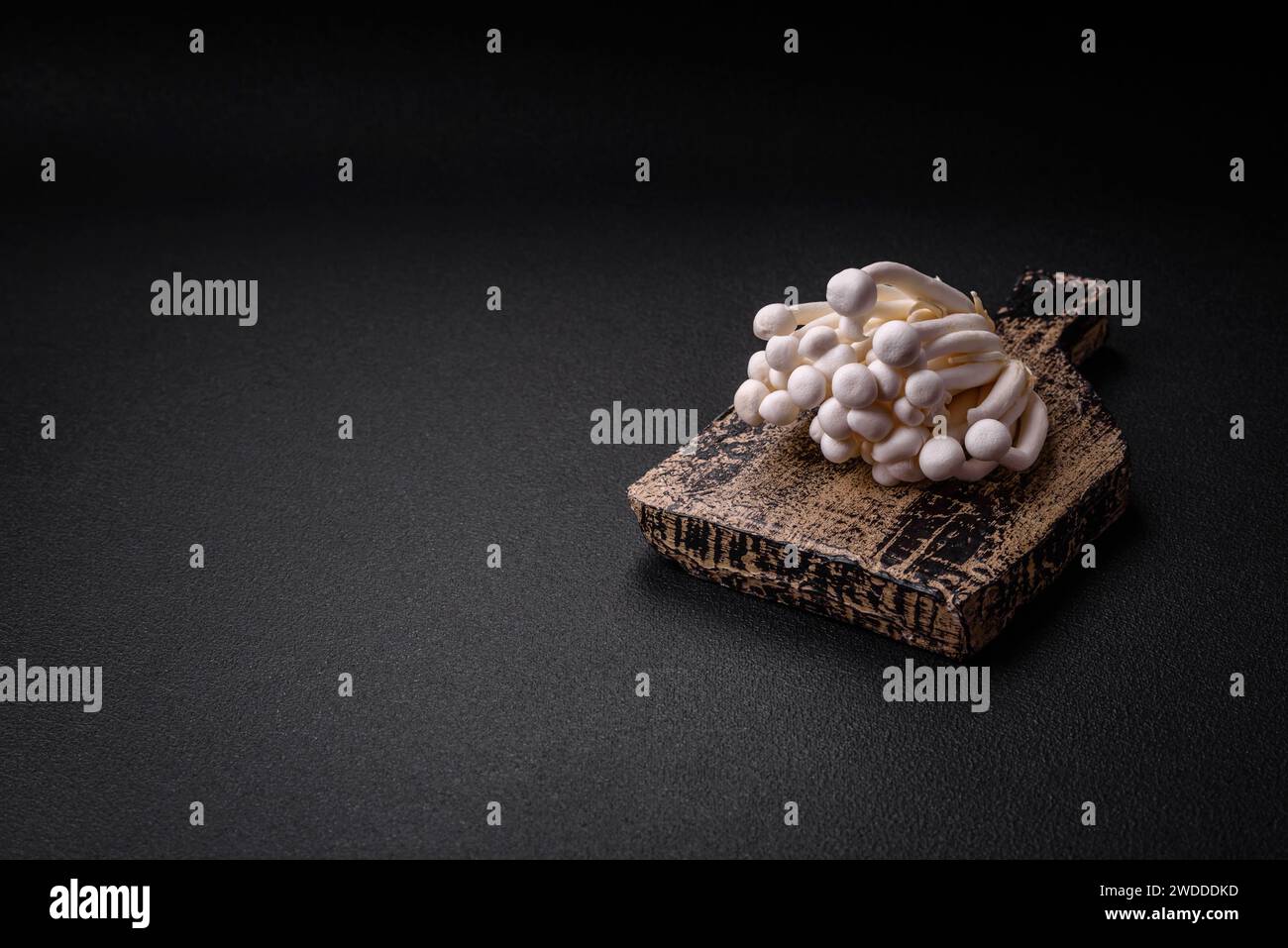 Small white edible beech mushrooms with salt and spices on a plain ...