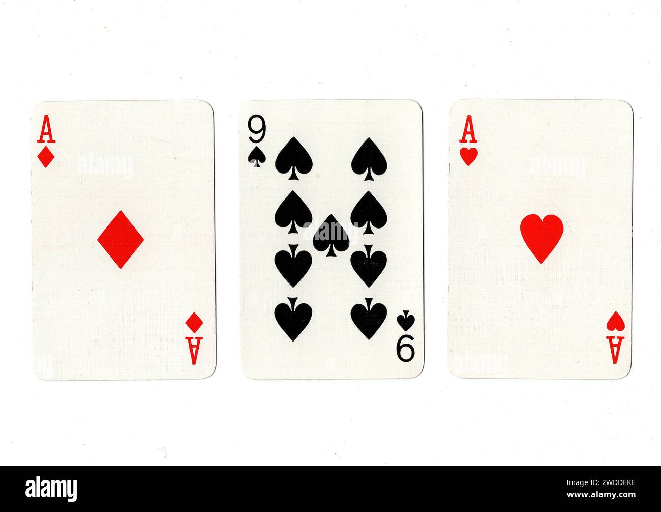 Vintage playing cards showing a pair of red aces and a black nine ...