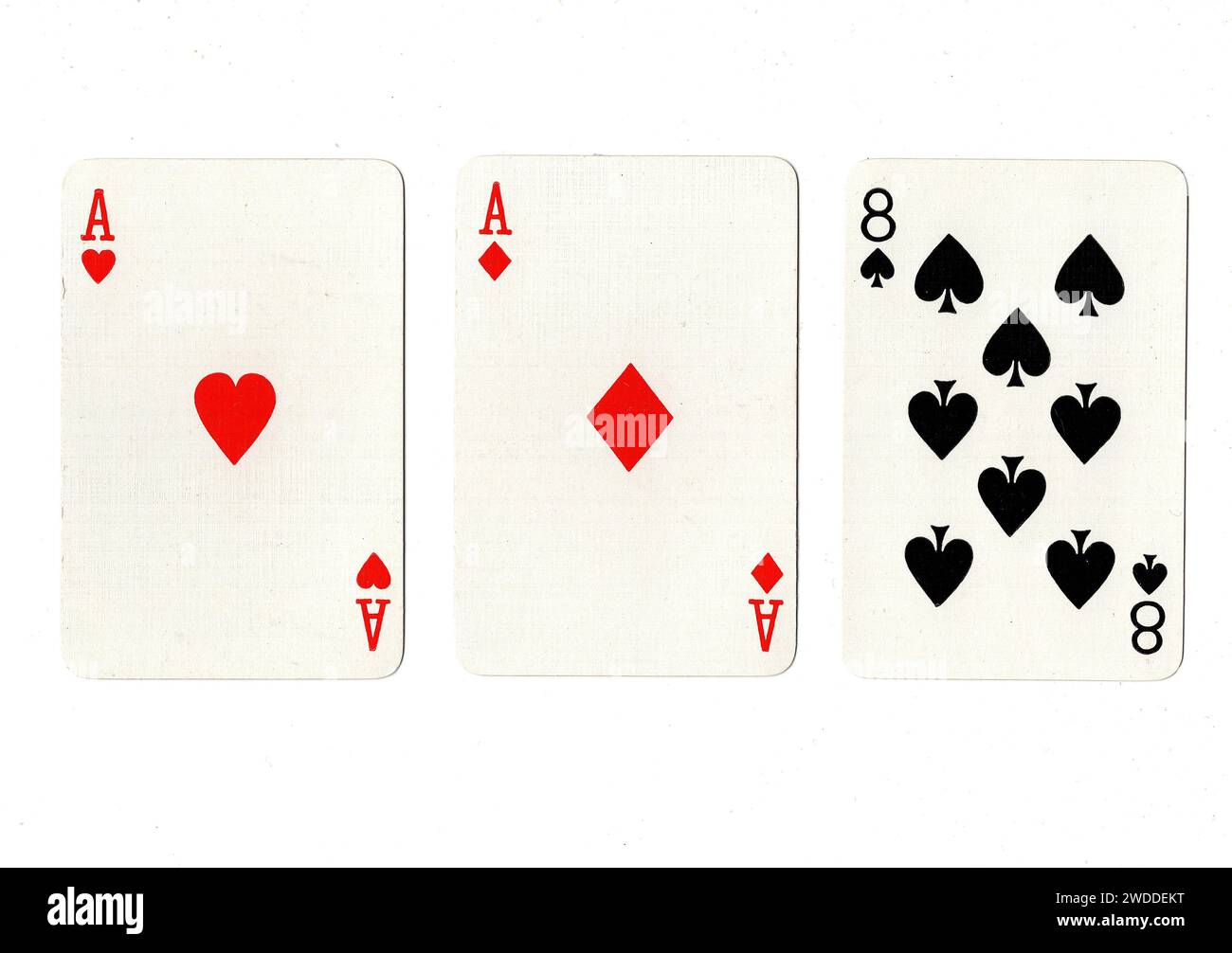 Vintage playing cards showing a pair of red aces and a black eight ...