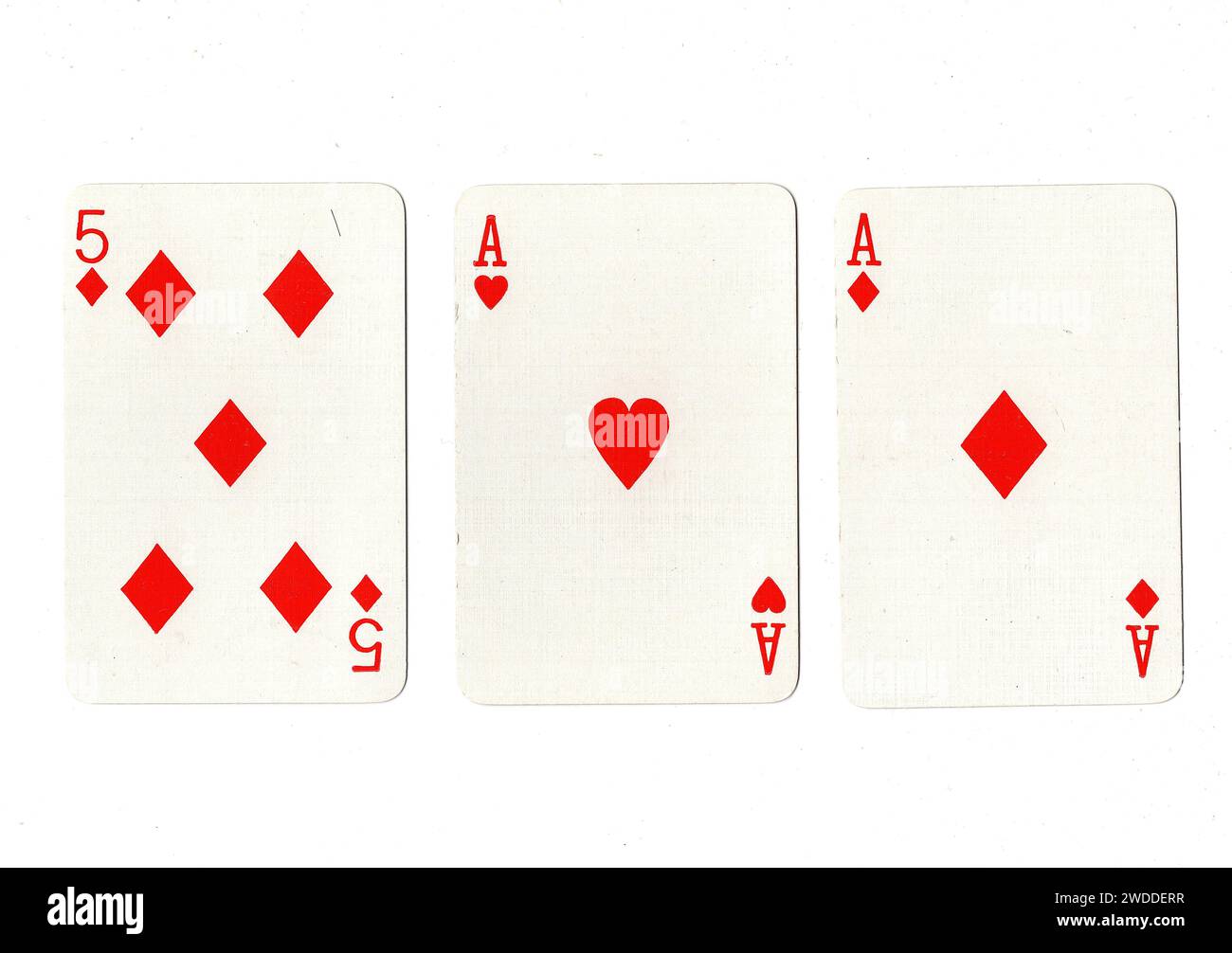 Vintage playing cards showing a pair of red aces and a red five ...