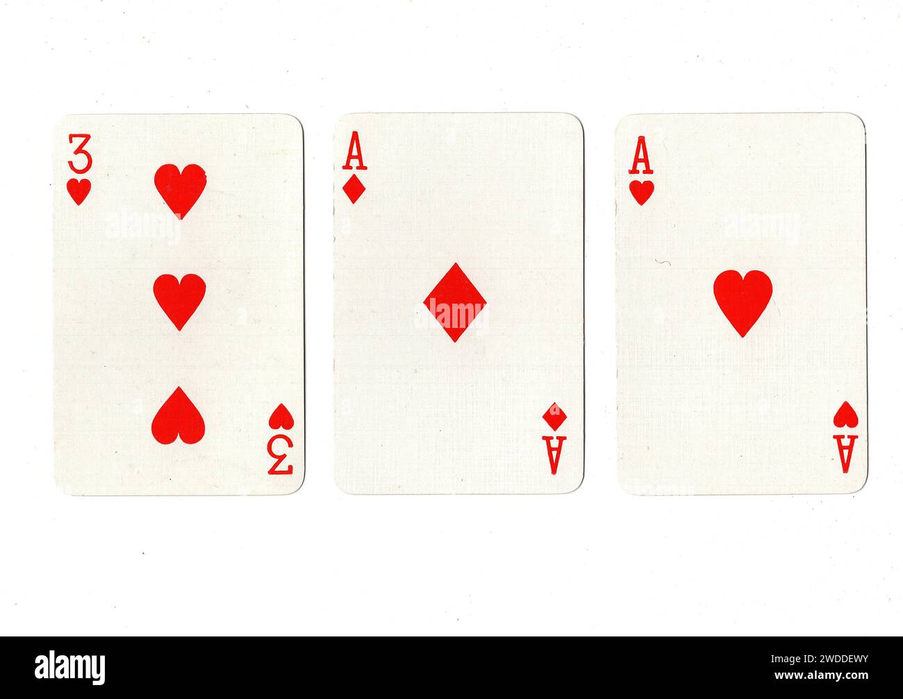 Vintage playing cards showing a pair of red aces and a red three ...