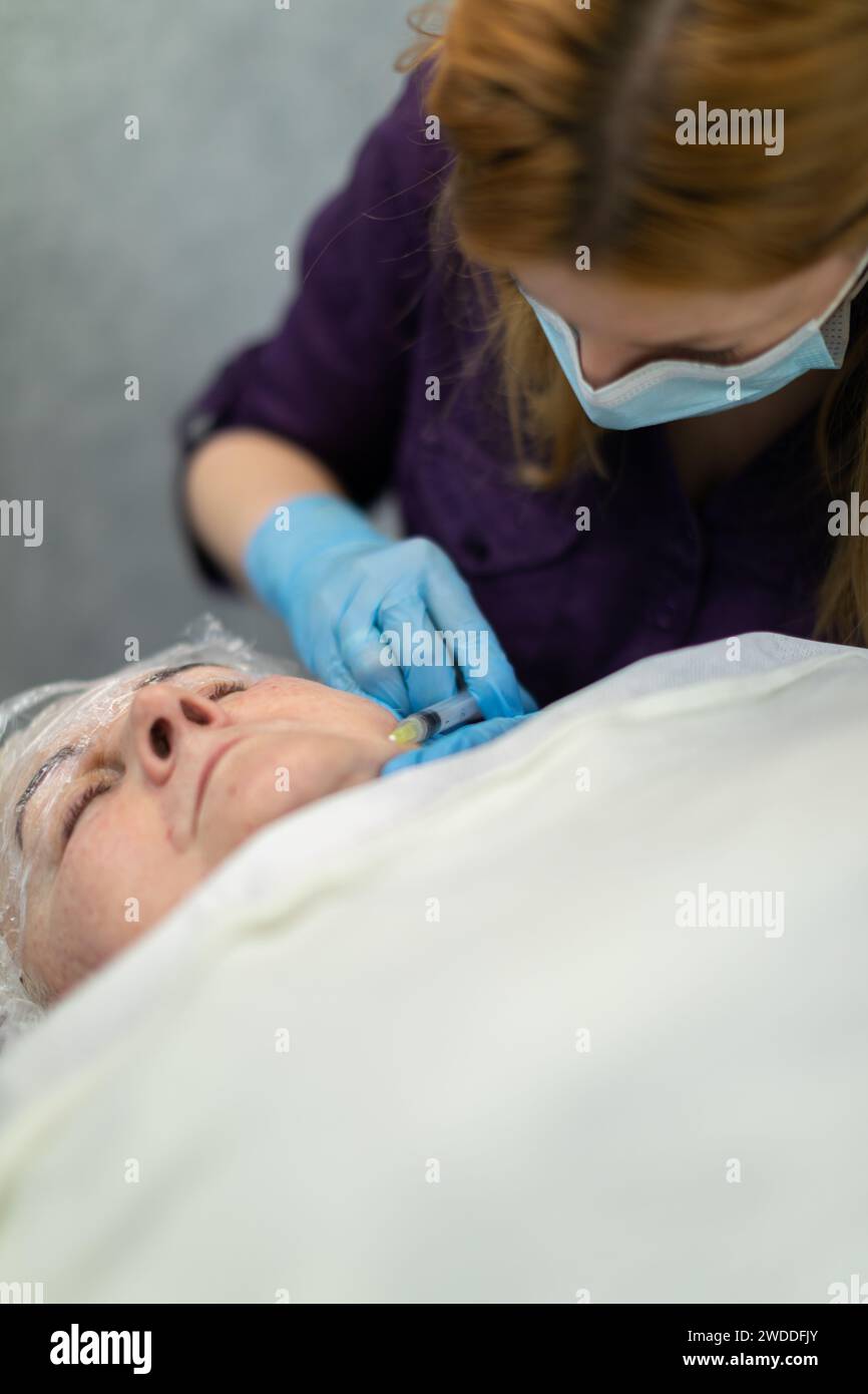 A cosmetologist gives injections into her patient's chin area Stock ...