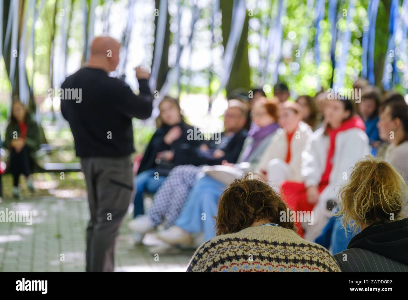 Engaging outdoor seminar captured with audience in focus and speaker ...