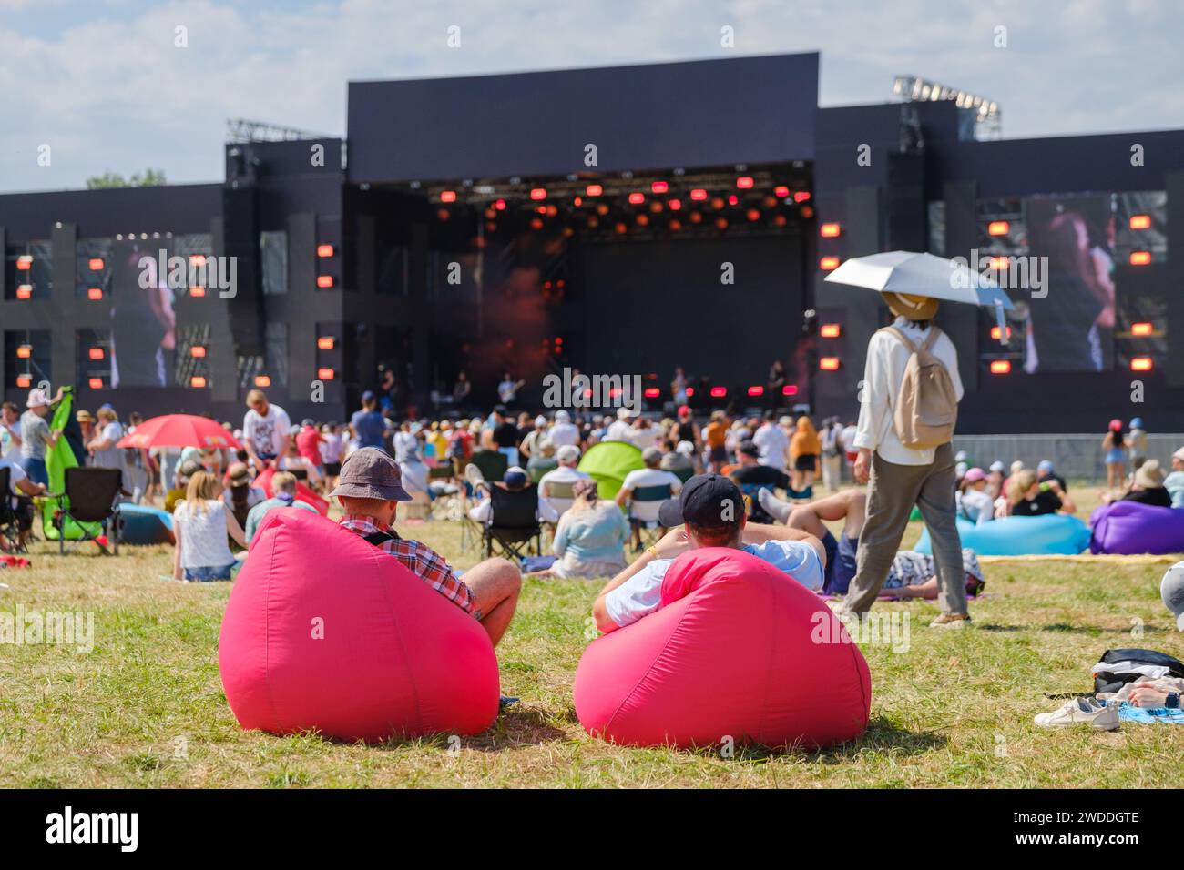 Summer festival vibes with enthusiastic crowd relaxing and watching a ...