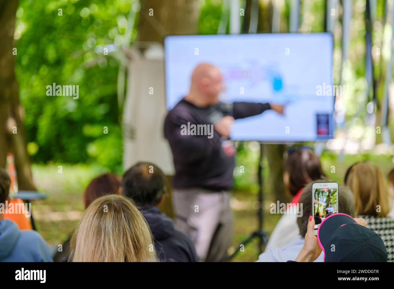 Man giving a presentation at an outdoor workshop while audience members ...
