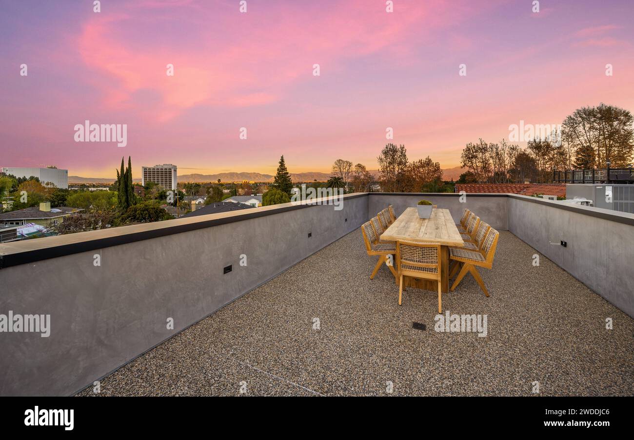 Table and chairs on rooftop terrace during sunset Stock Photo - Alamy