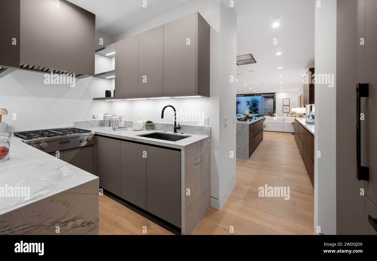 Dark wooden cabinets and a sleek silver countertop in a modern kitchen ...