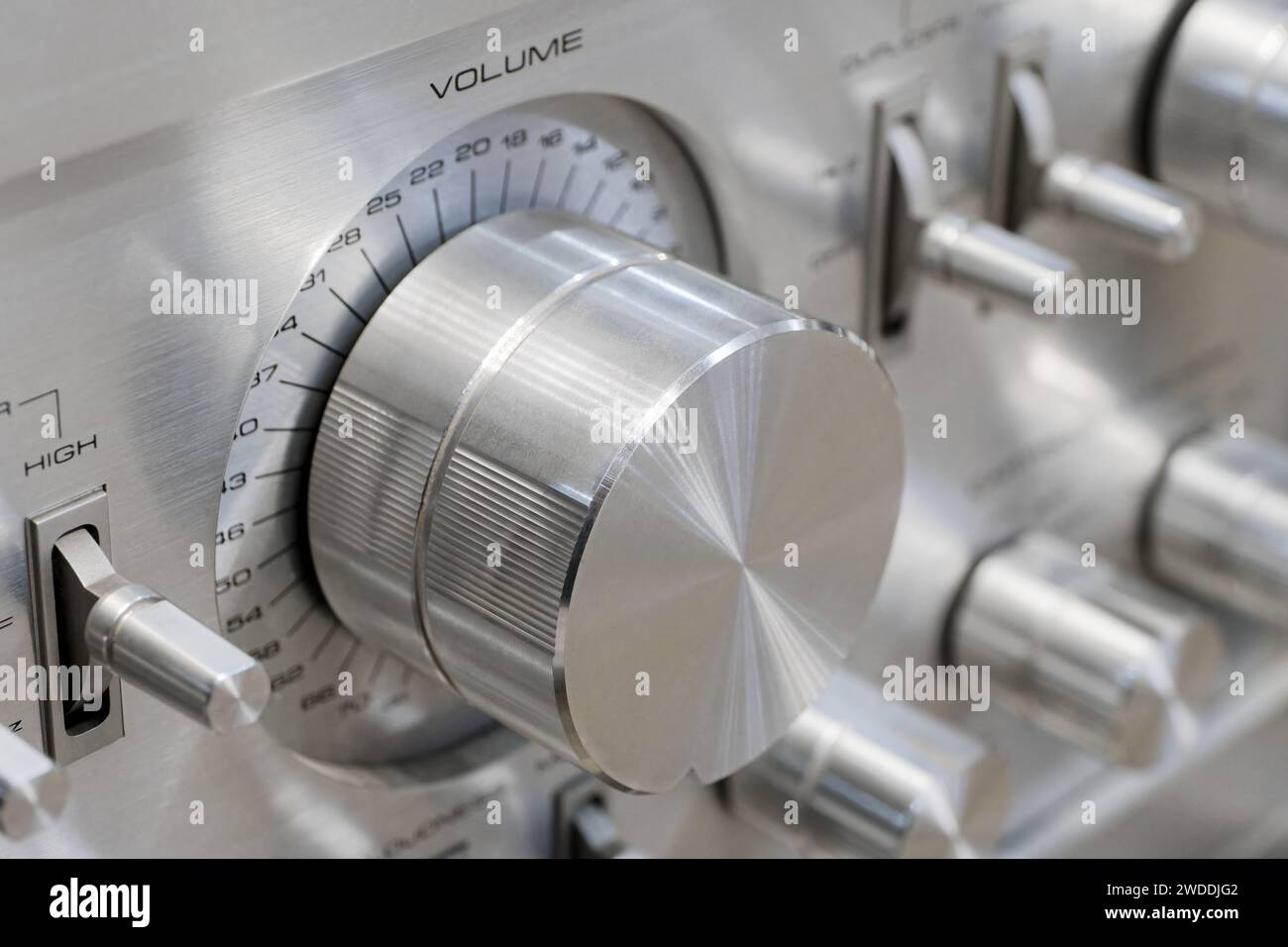 Old vintage stereo amplifier, aluminium front panel with knobs, buttons, dials and switches ...