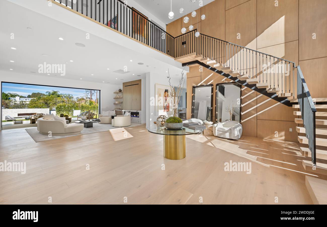 Modern wood furniture and bright glass windows in a spacious home with ...