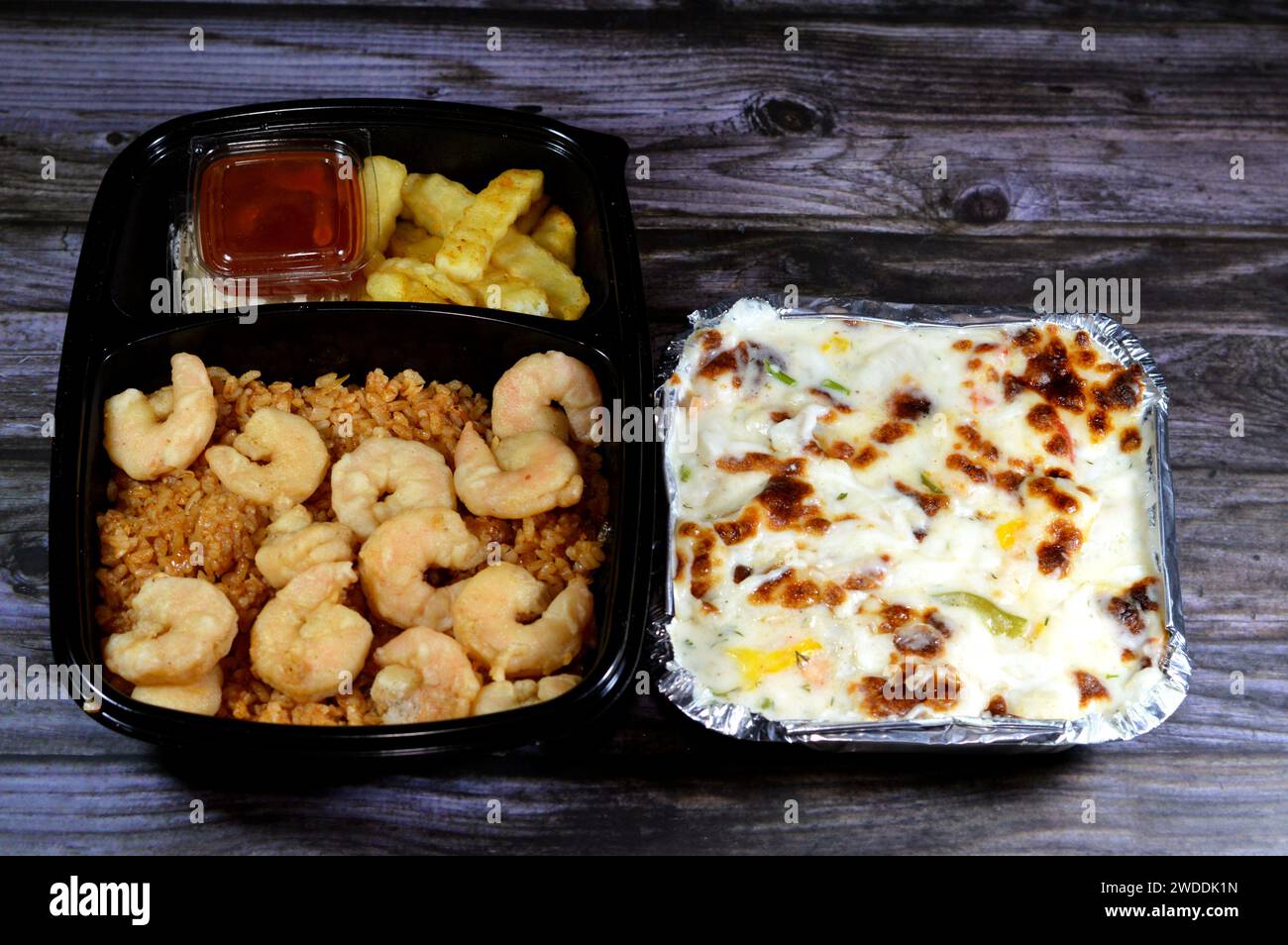 A creamy seafood casserole pot shrimps, squid calamari, fish fillet ...