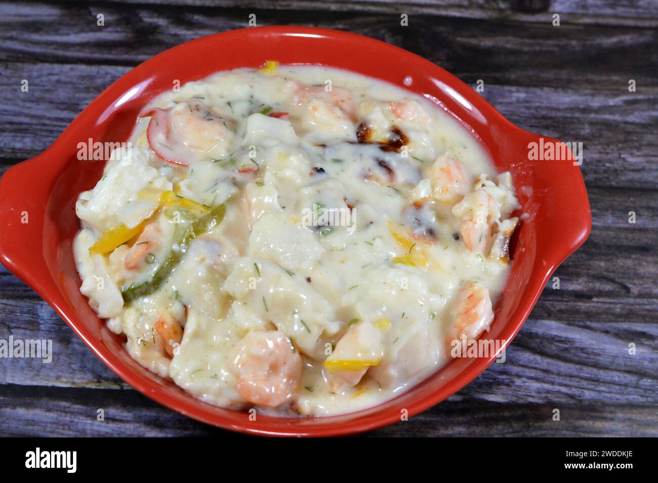 Creamy seafood casserole pot shrimps, squid calamari, fish fillet ...