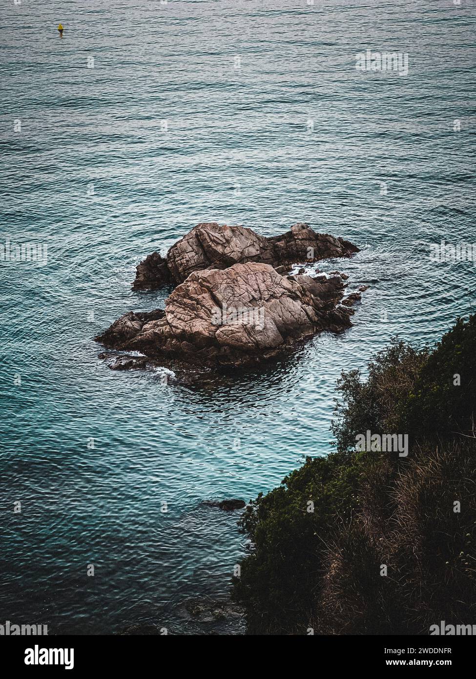 A scenic island surrounded by rugged rocks and a dramatic coastline ...