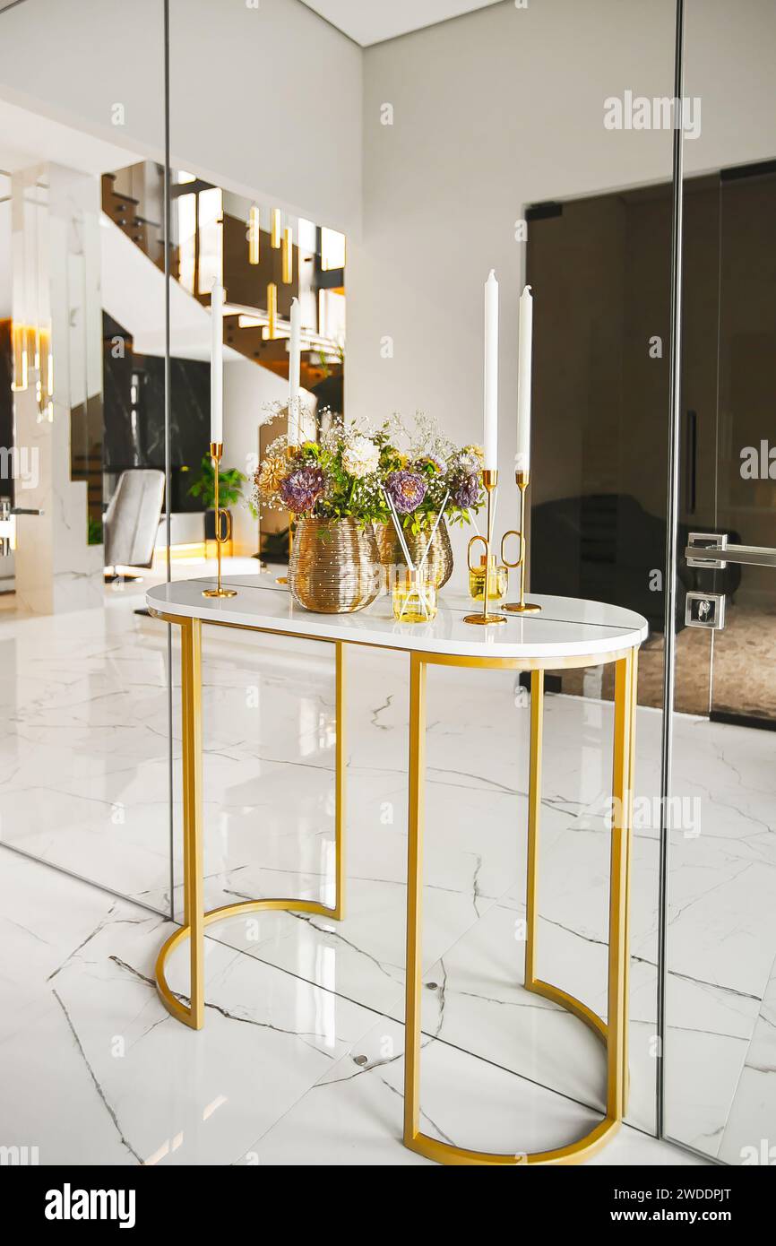 Elegant console table with flowers in vase in trendy lobby interior ...