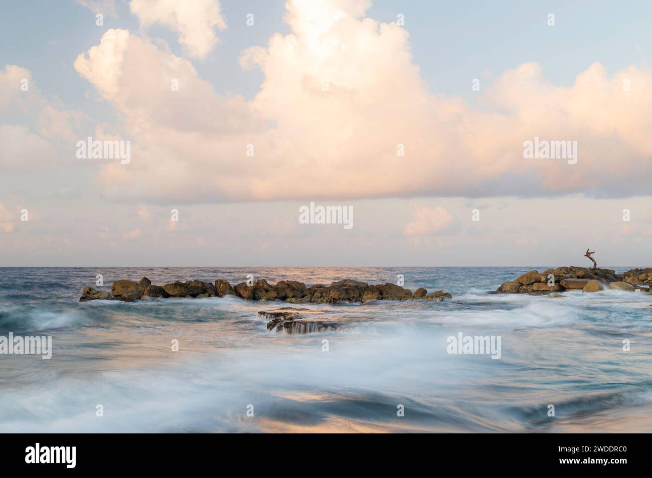 Ocean water, cascading over rocks and reef, on the shoreline of Curacao ...