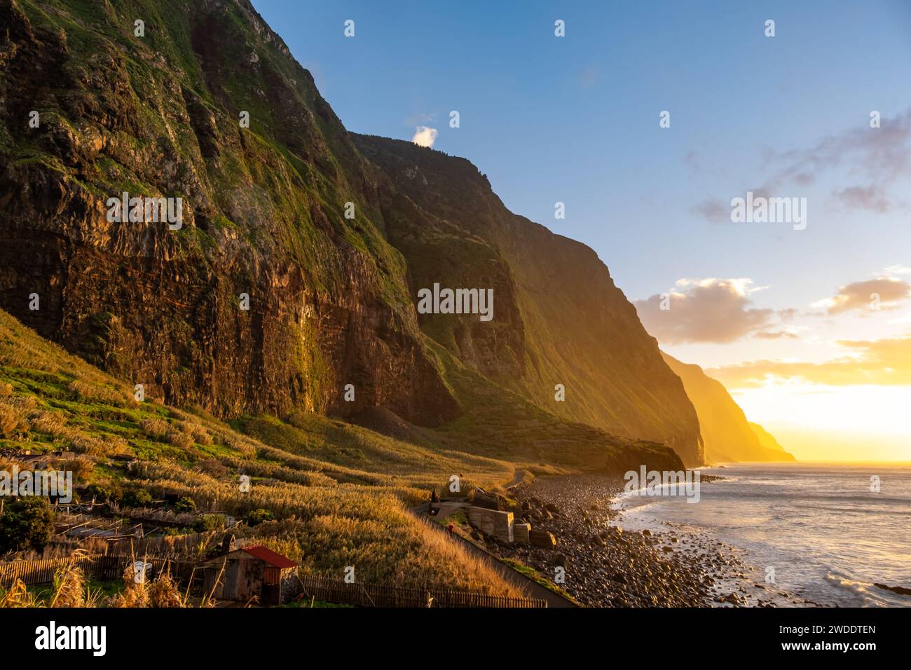 Volcanic rock cliffs Achadas da Cruz in backlit sunlight. Waves of the ...