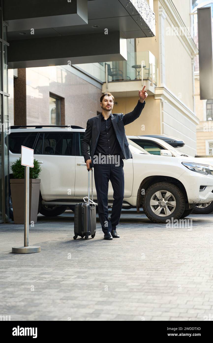 Young man standing and raising hand to call a taxi Stock Photo - Alamy