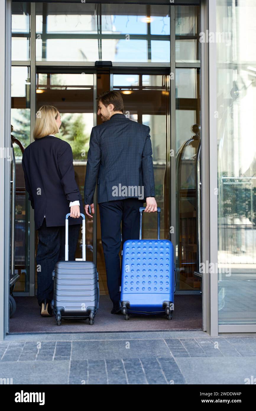 Back view photo of couple entering hotel with suitcases Stock Photo - Alamy