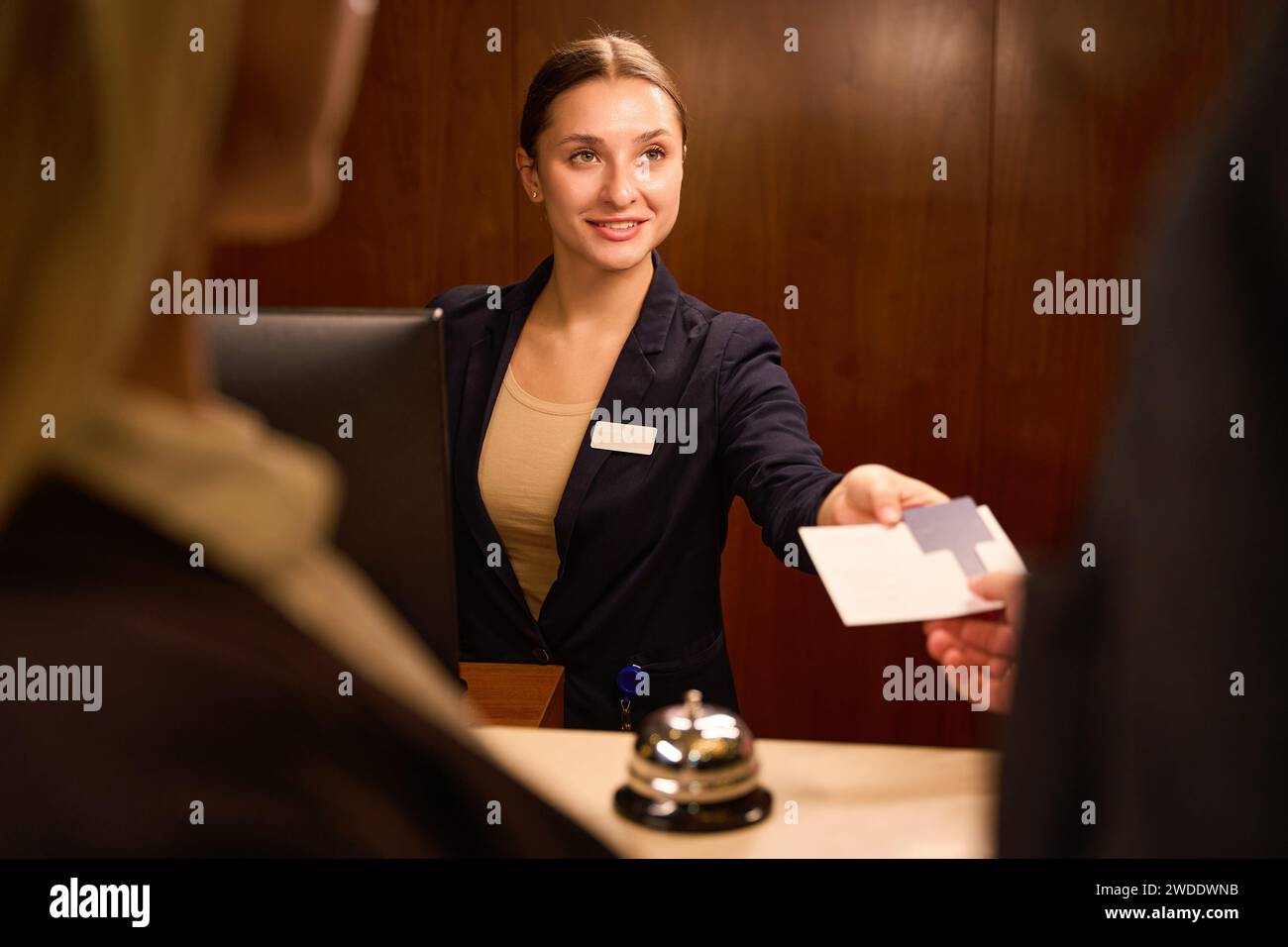 Smiling receptionist standing and giving keycard to hotel guest Stock ...