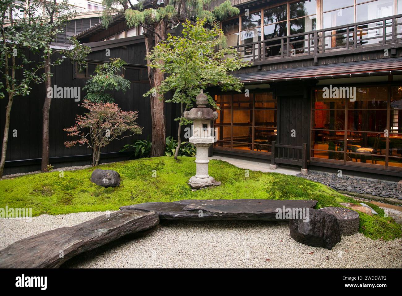 Traditional Japanese garden with a stone sculpture in a traditional tea ...