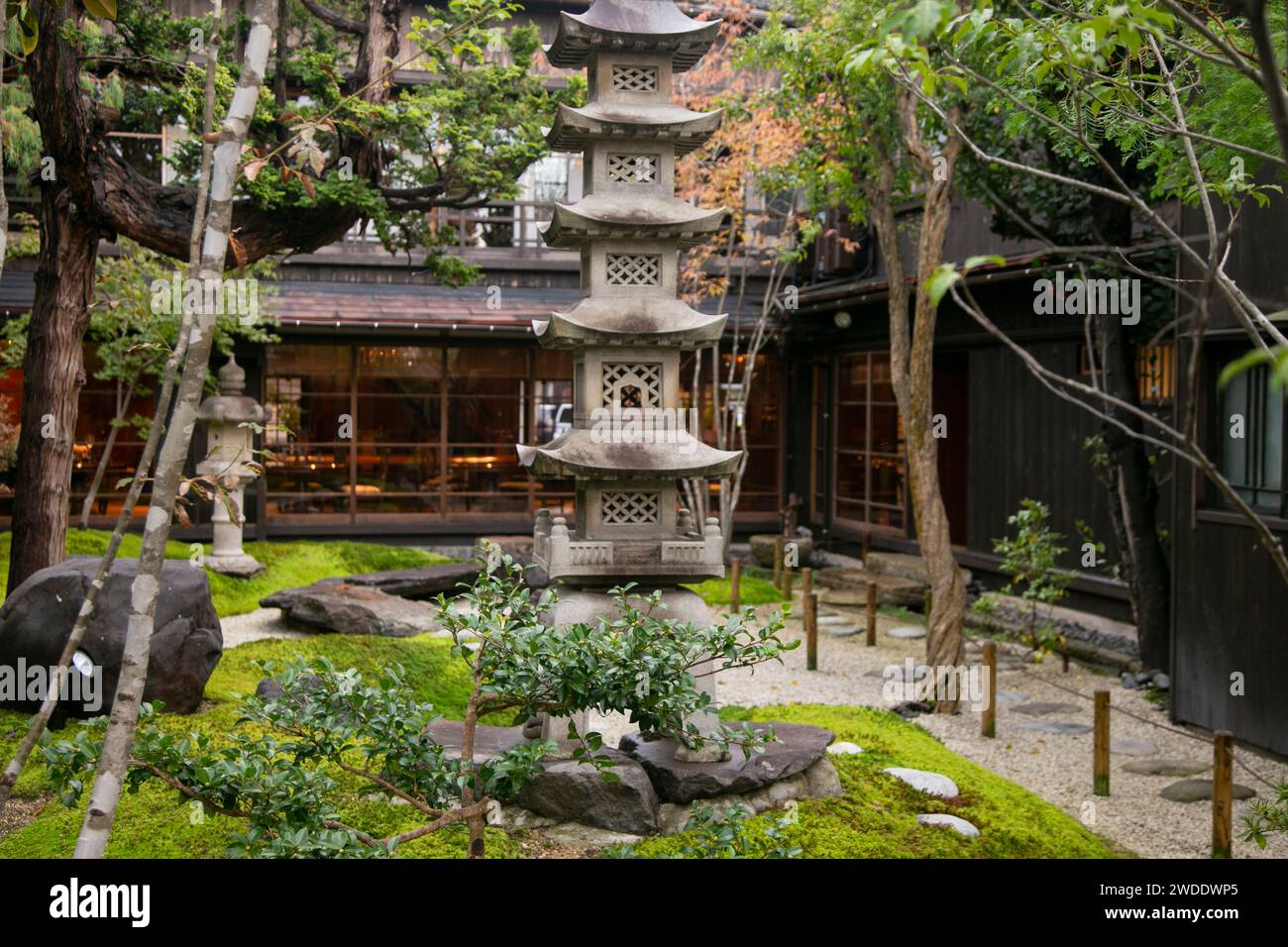 Traditional Japanese garden with a stone sculpture in a traditional tea ...