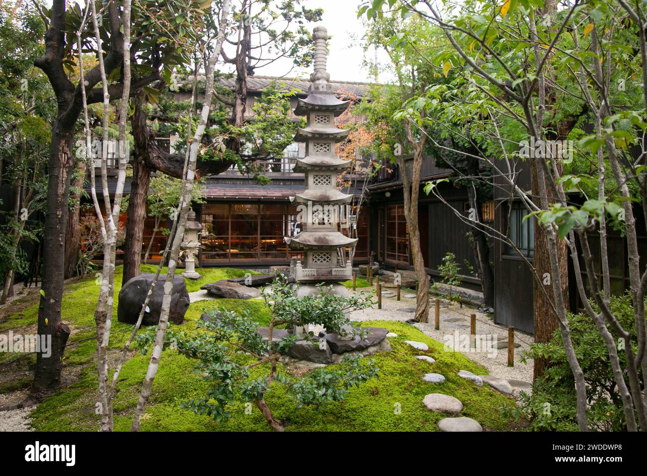 Traditional Japanese garden with a stone sculpture in a traditional tea ...