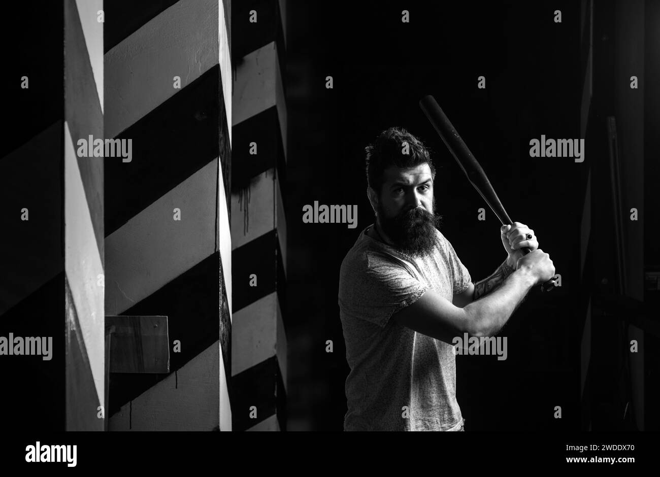 Angry man in t-shirt. Ready to swing. Gangster with bat weapon. Bearded ...
