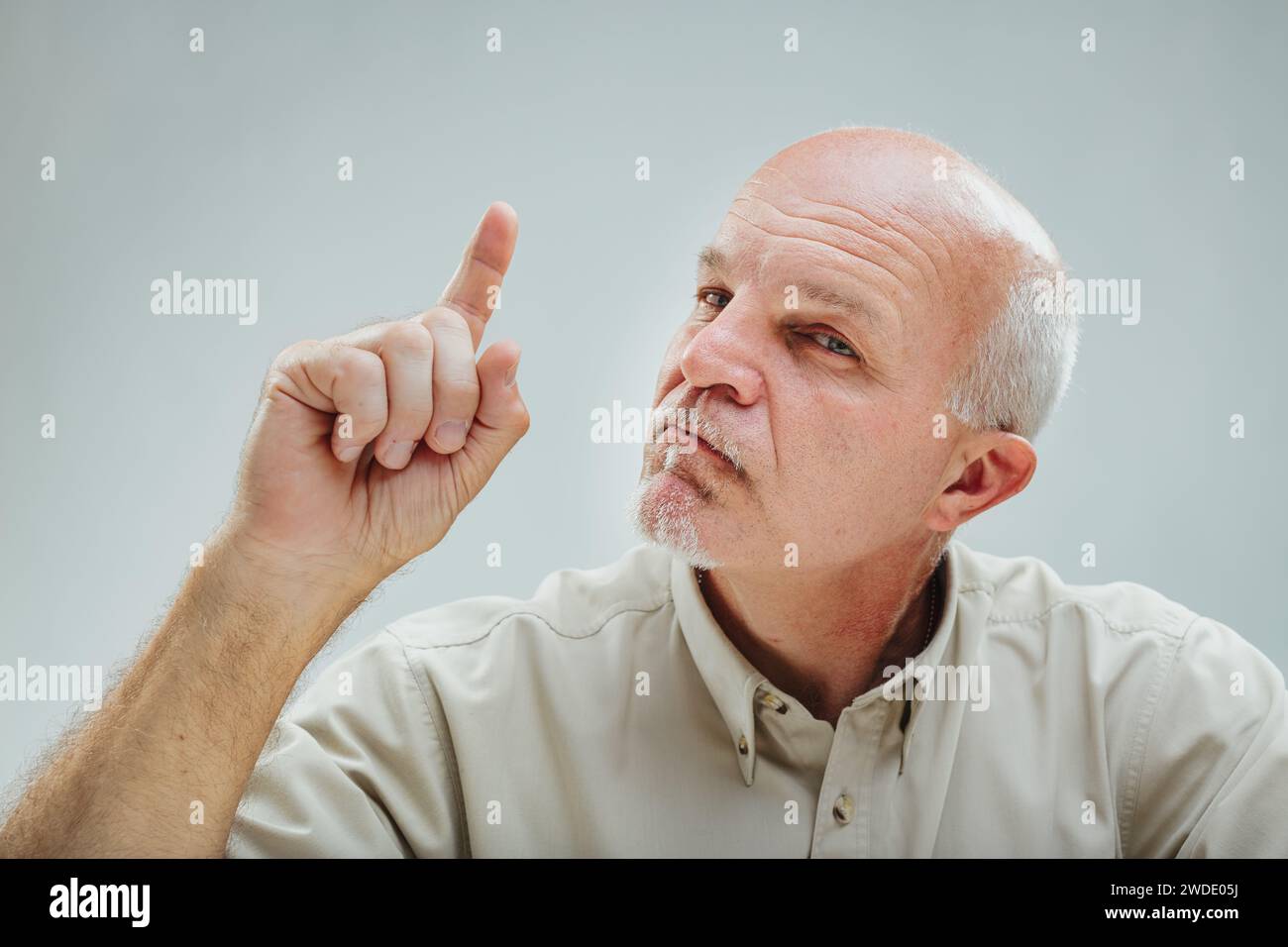 Mature man experiences a moment of realization, raising his index ...