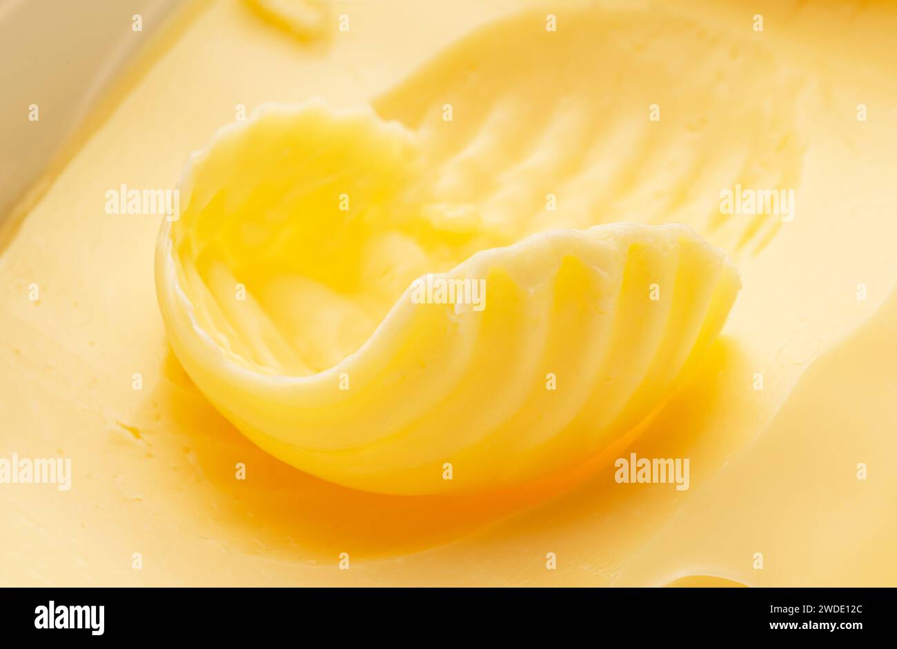 Butter curl over the piece of the butter closeup. Food background Stock ...