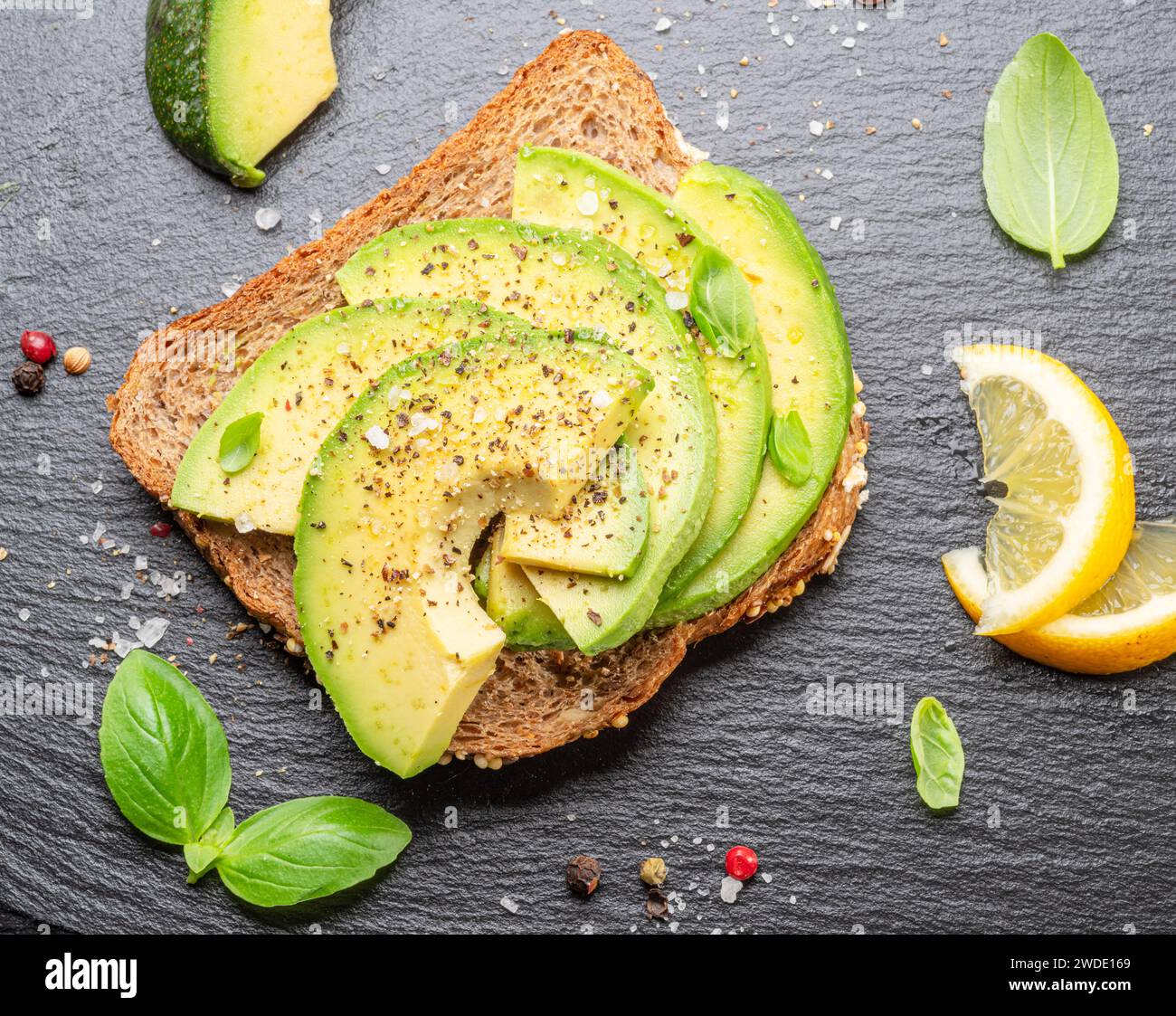 Avocado toast - bread with avocado slices on natural slate serving ...