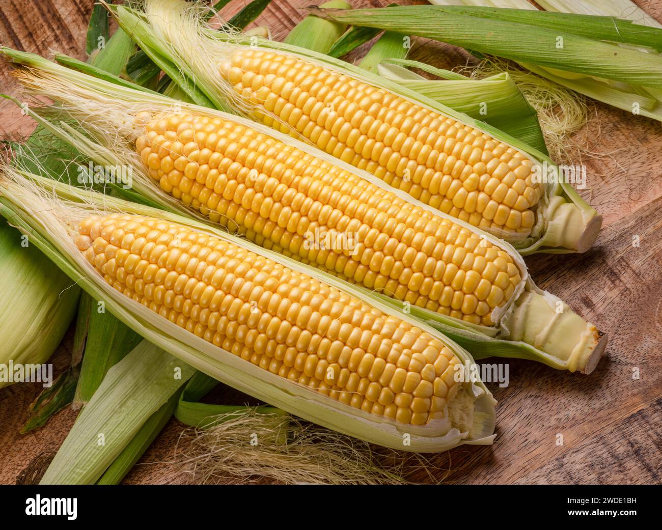 Ripe corn heads with corn whiskers and leaves. Nice vegetable cooking ...