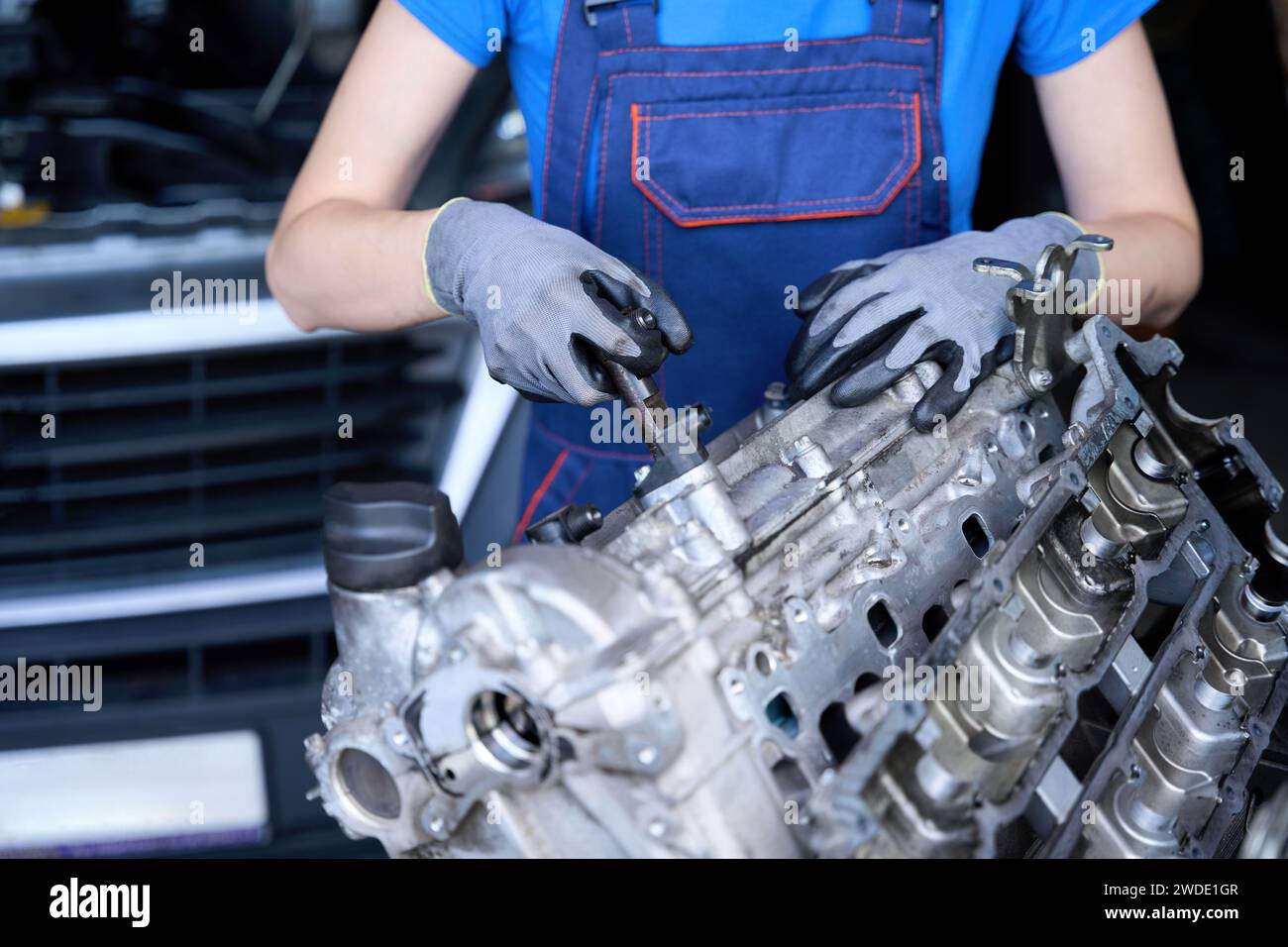 Woman auto mechanic at the workplace repairs a motor Stock Photo - Alamy